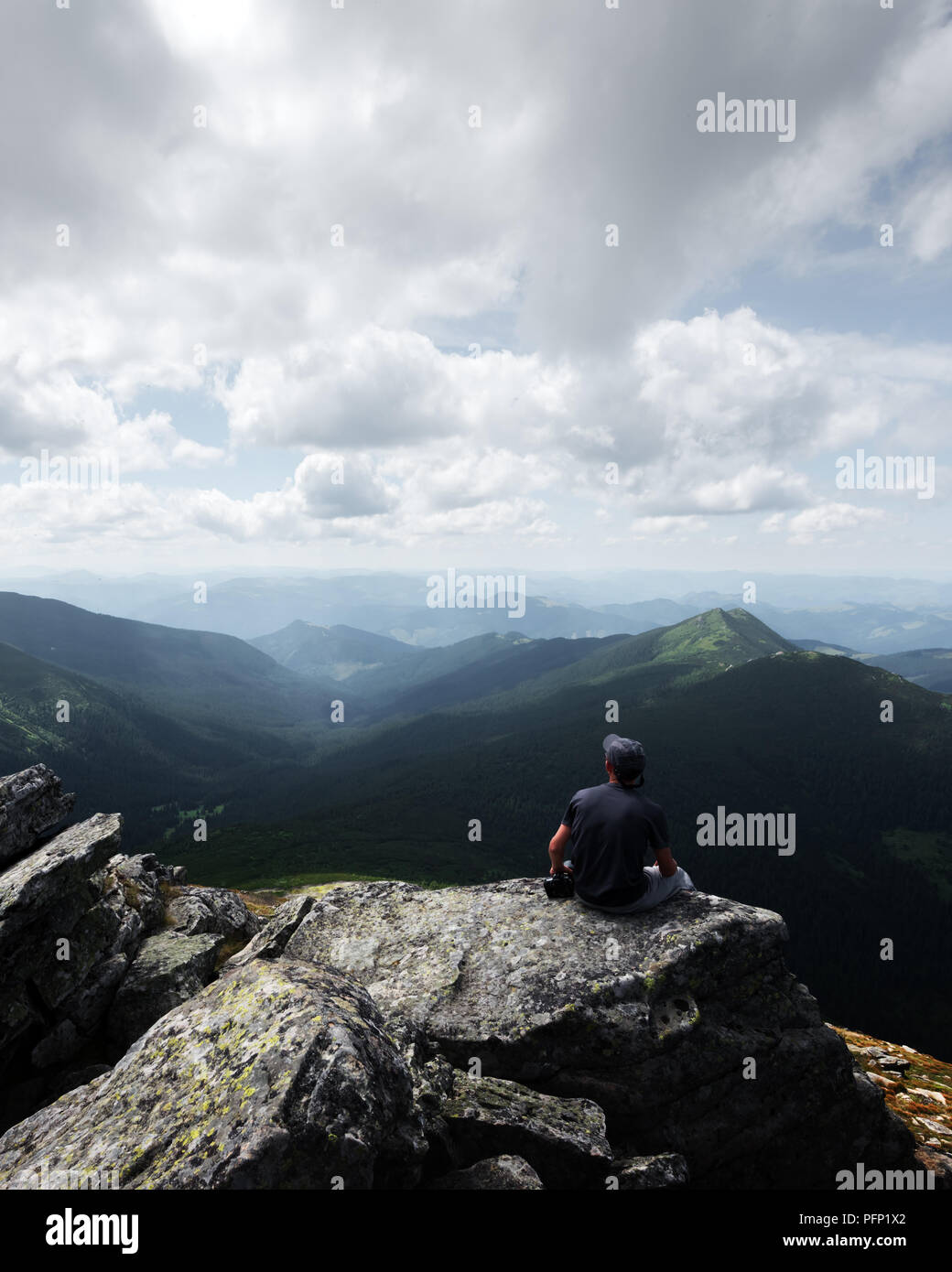Young man sitting by cliff edge hi-res stock photography and images - Alamy