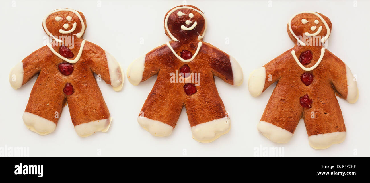 Three gingerbread men with white icing Stock Photo - Alamy