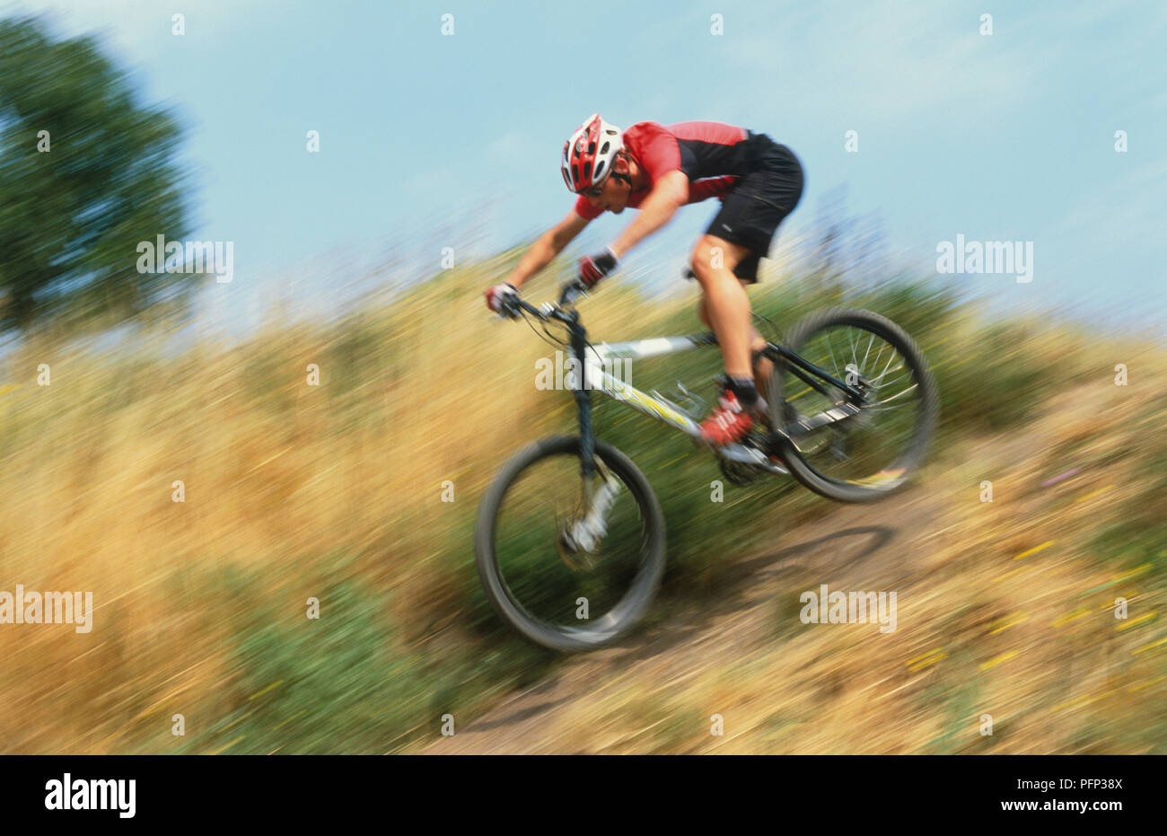 Man cycling over a ridge, dirt track, grass, motion blur Stock Photo ...