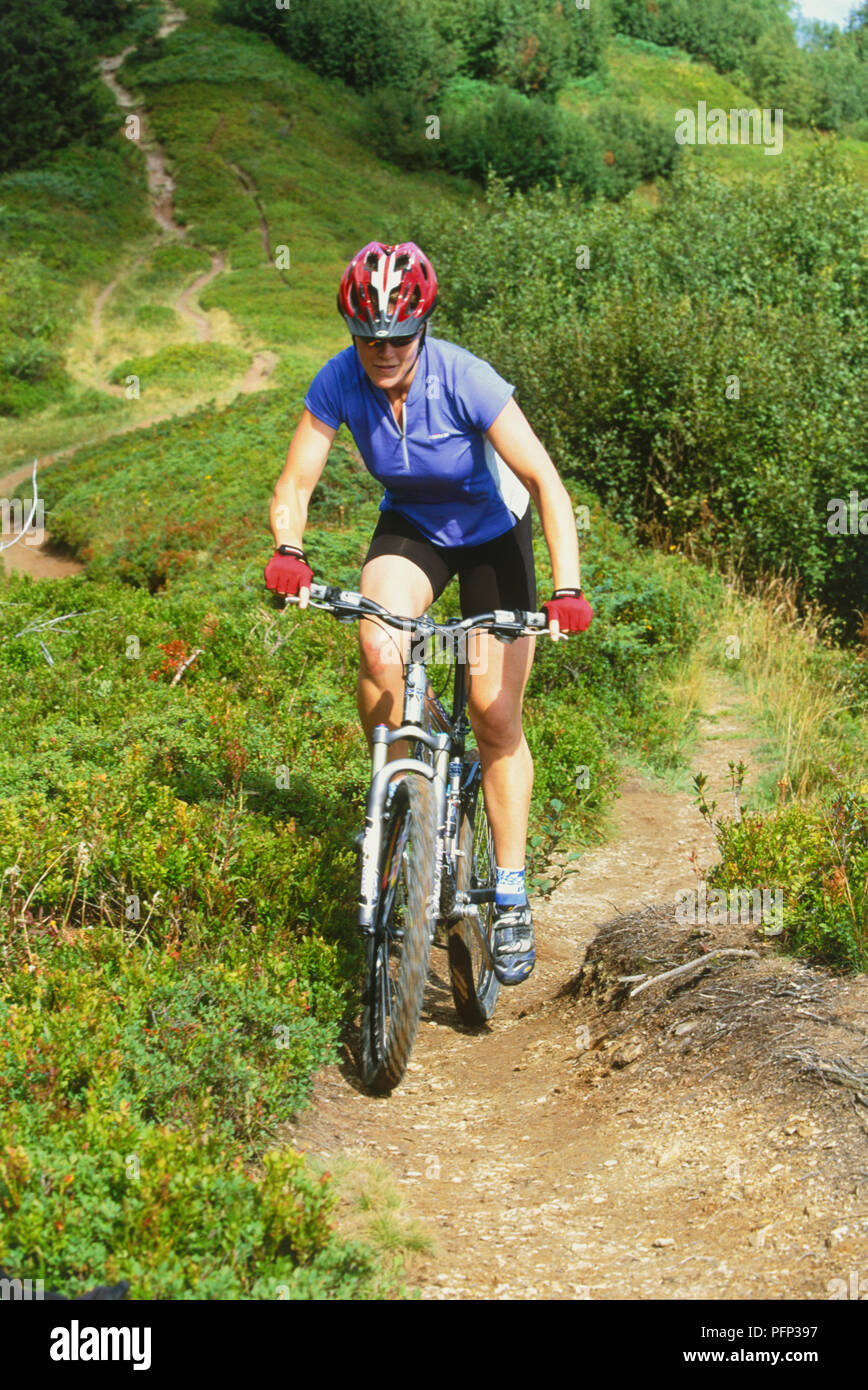 Female cyclist riding up singletrack Stock Photo - Alamy