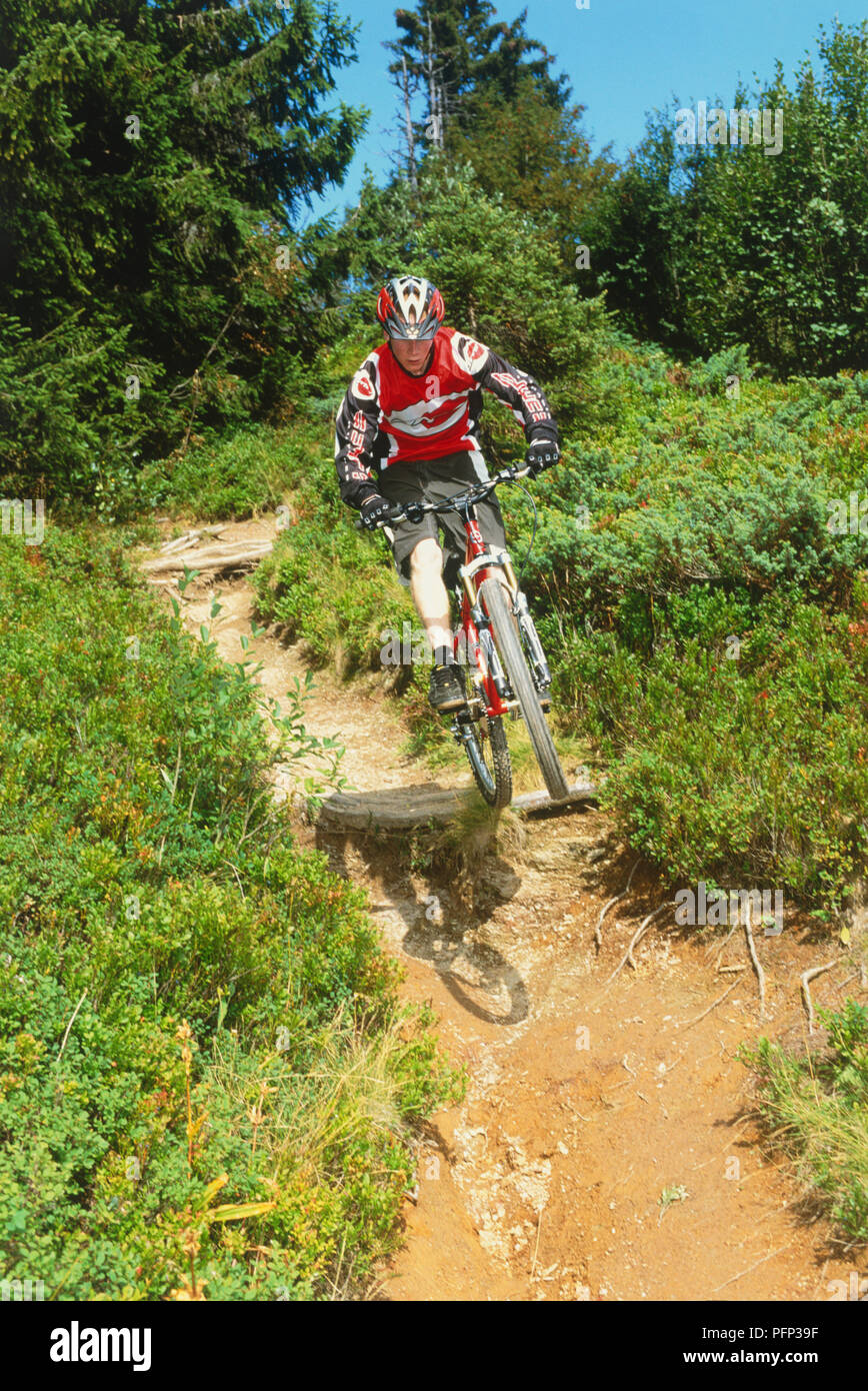 Male cyclist leaping with bike over obstacles in the path Stock Photo ...