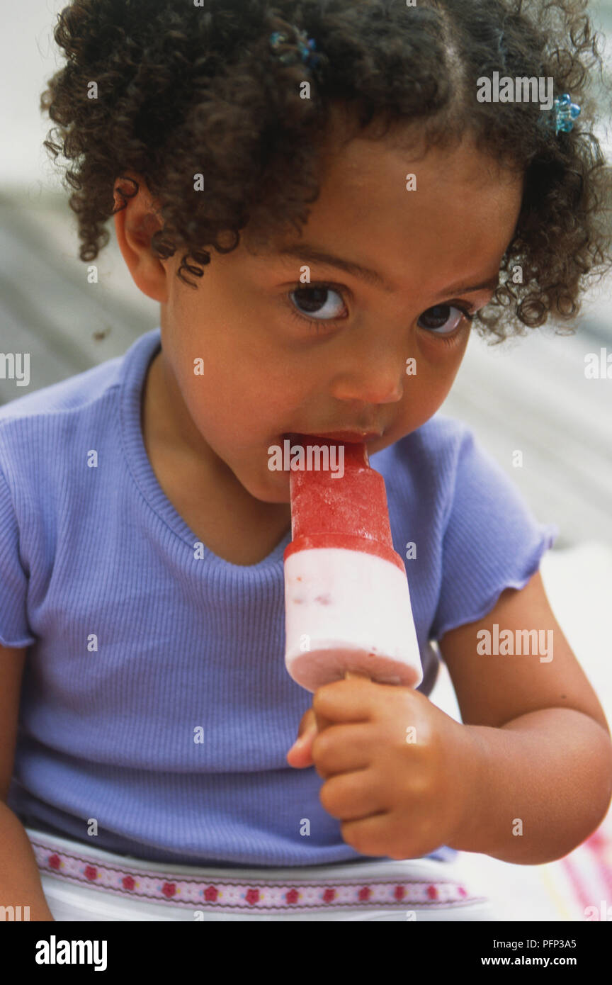 Girl eating an iced lolly Stock Photo - Alamy