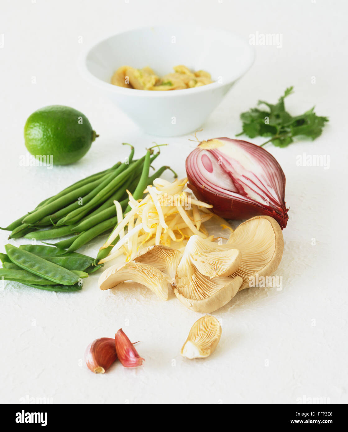 Halved red onion, garlic cloves, mangetout, runner beans, beansprouts ...