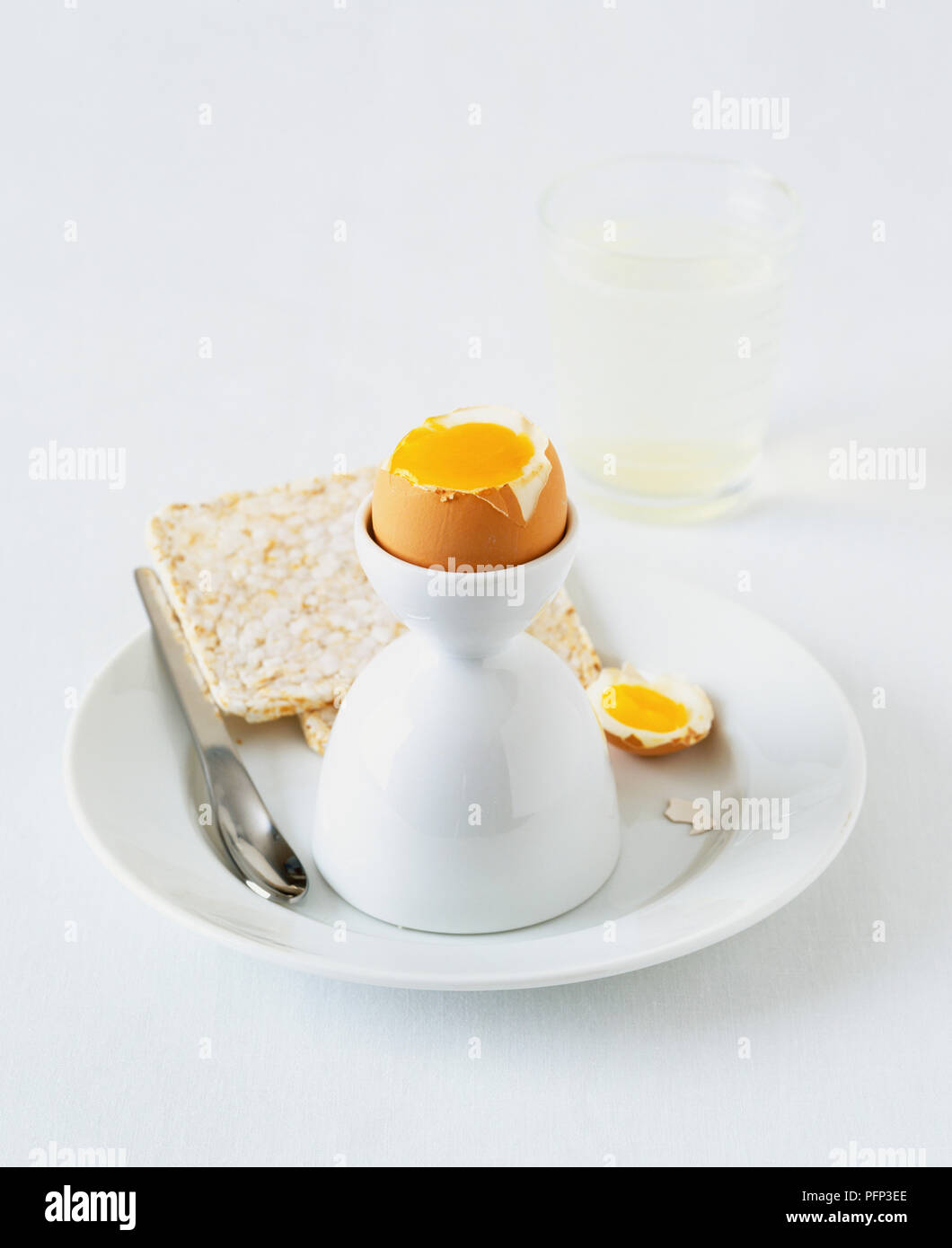 Free-range hard boiled egg served with rice cakes and glass of hot ...