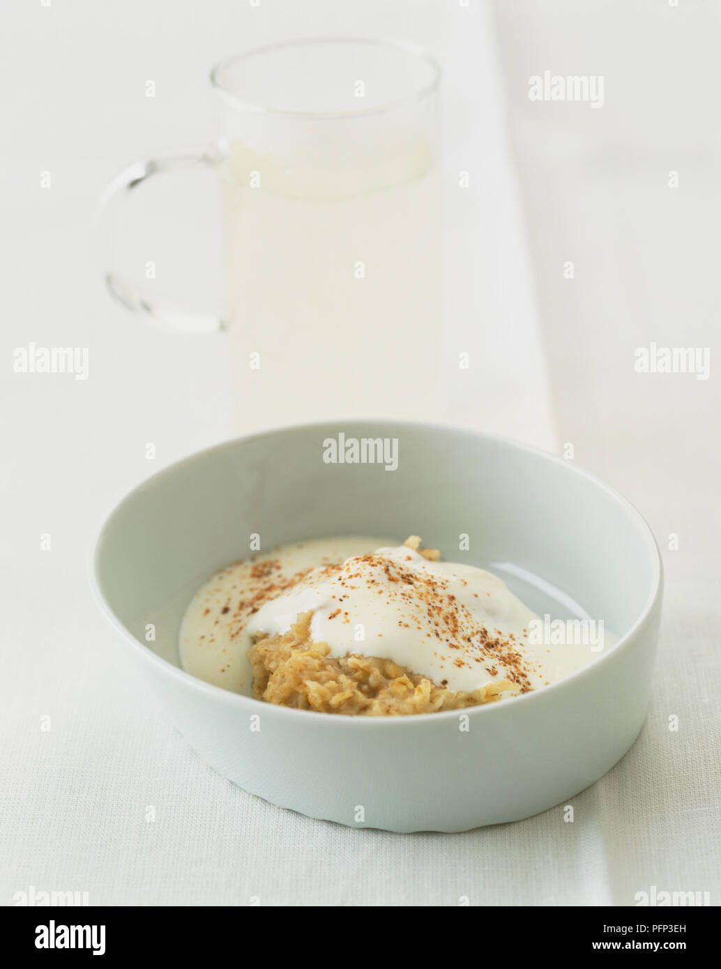 Boiled porridge oats served in white ceramic bowl with live natural ...