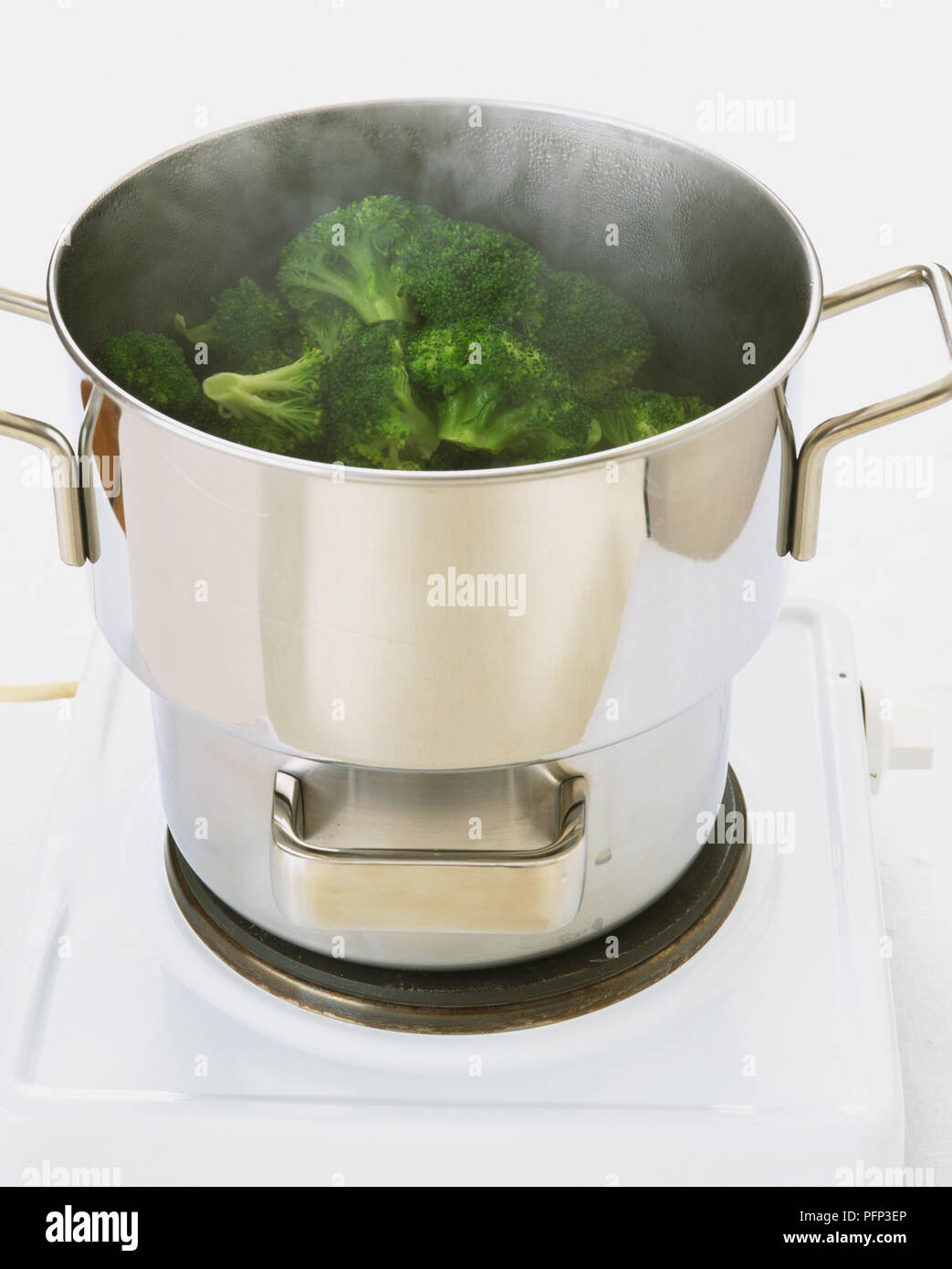 Broccoli florets steaming in metal hob steamer Stock Photo - Alamy