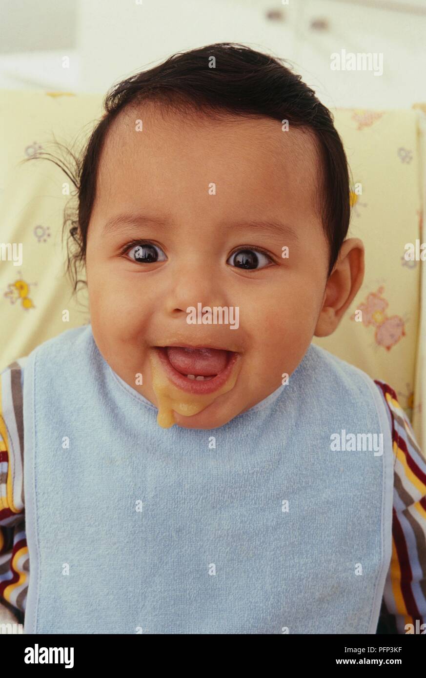Baby boy with mouth open and food dripping down chin Stock Photo - Alamy