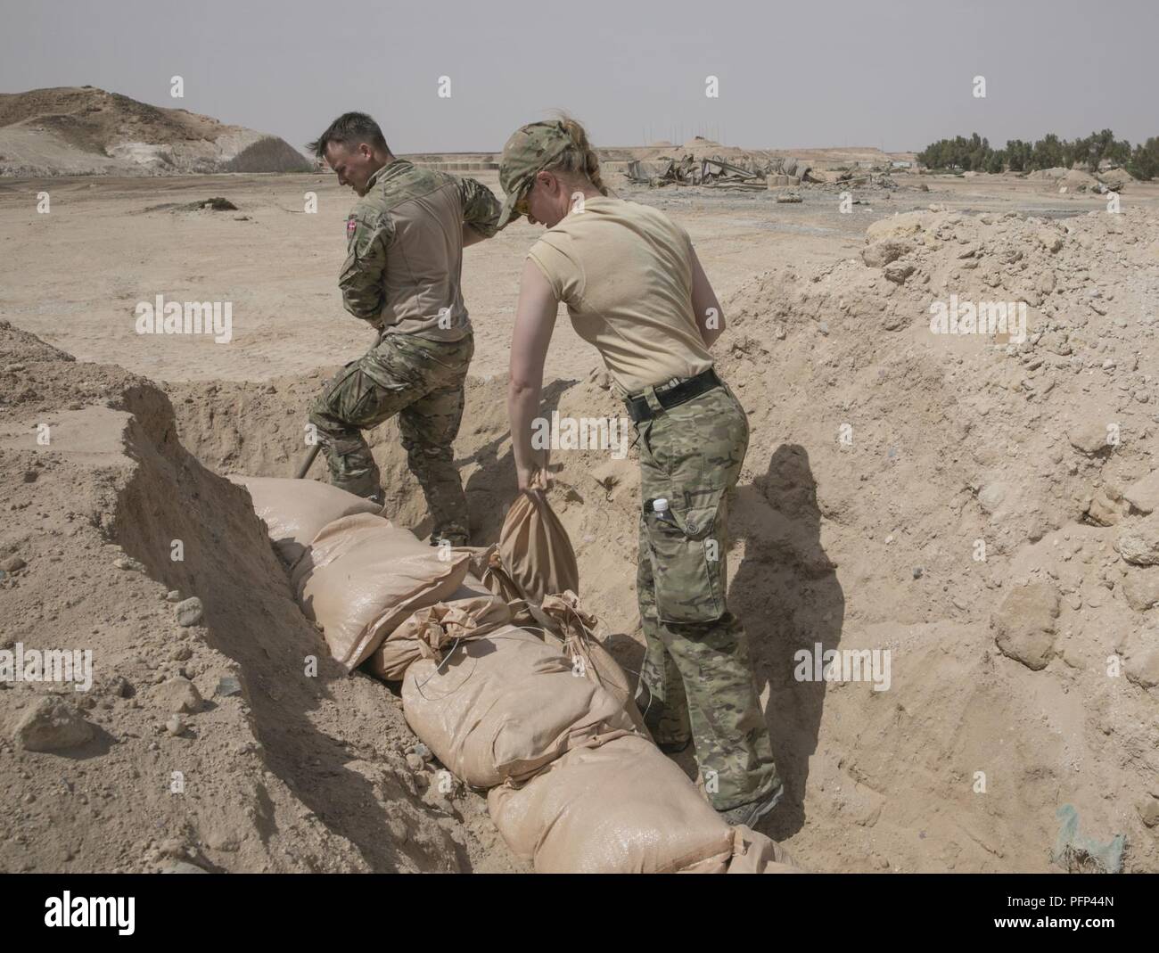 A Danish soldiers fill a defense trench with sand bags for an upcoming ...