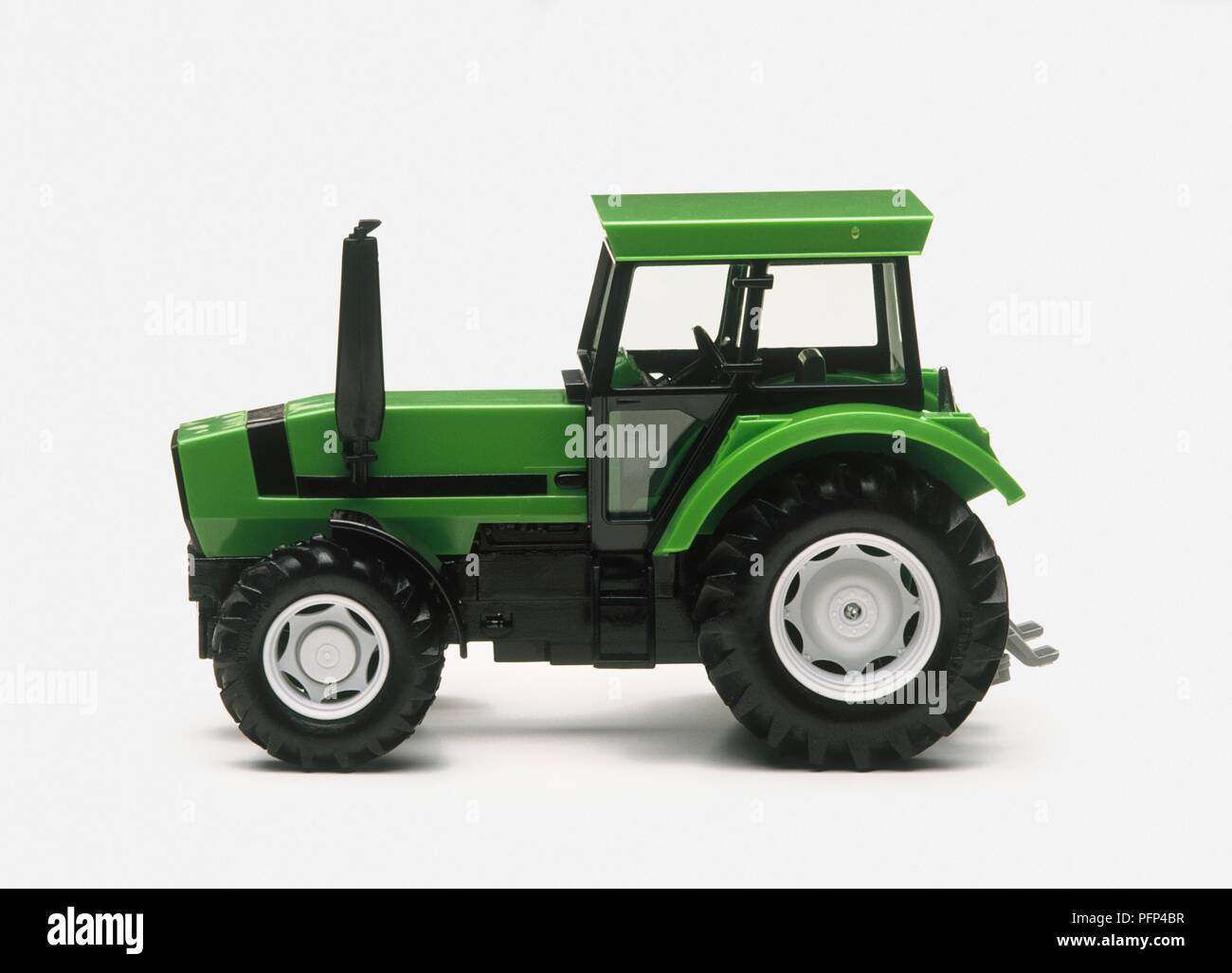 Green toy tractor, side view Stock Photo - Alamy