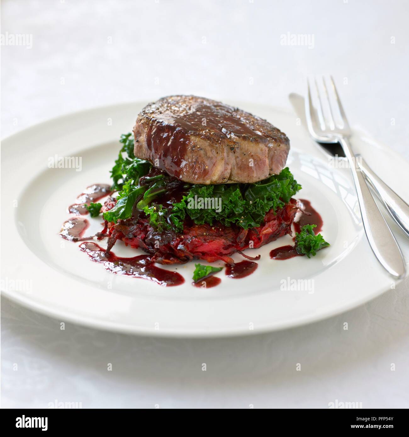 Steak and beetroot rosti served with broccoli on white plate Stock ...