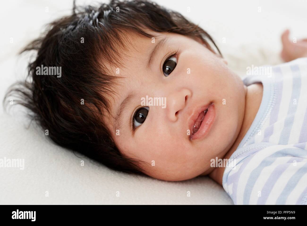 Headshot of baby boy lying on back, looking at camera Stock Photo - Alamy