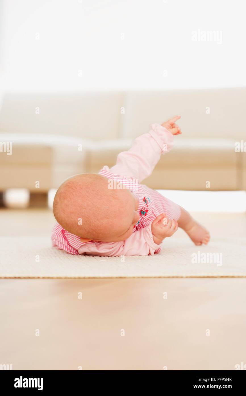Baby girl rolling on the floor Stock Photo - Alamy