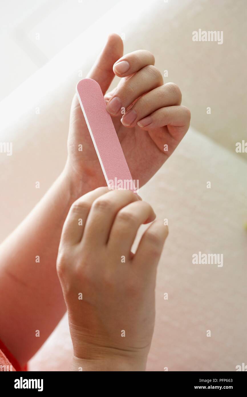 Young woman filing fingernails hi-res stock photography and images - Alamy