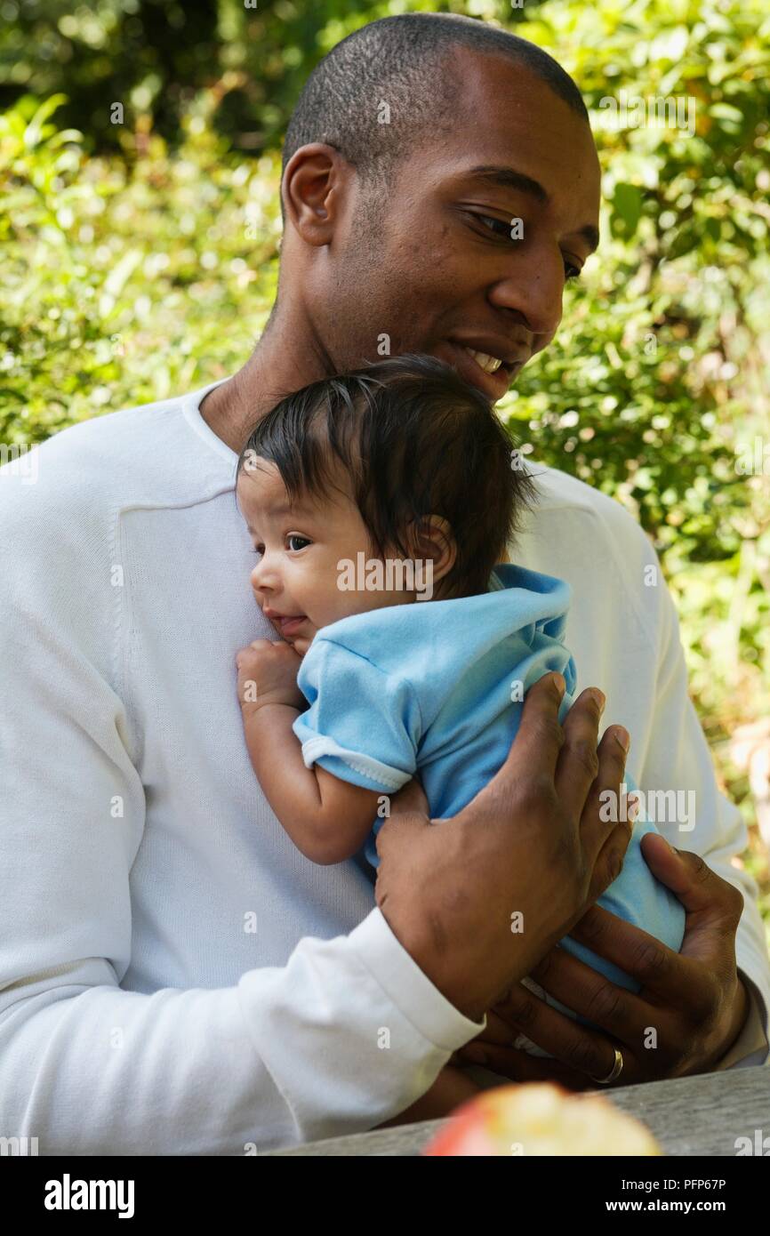 Man holding a baby boy close to his chest, close-up Stock Photo - Alamy
