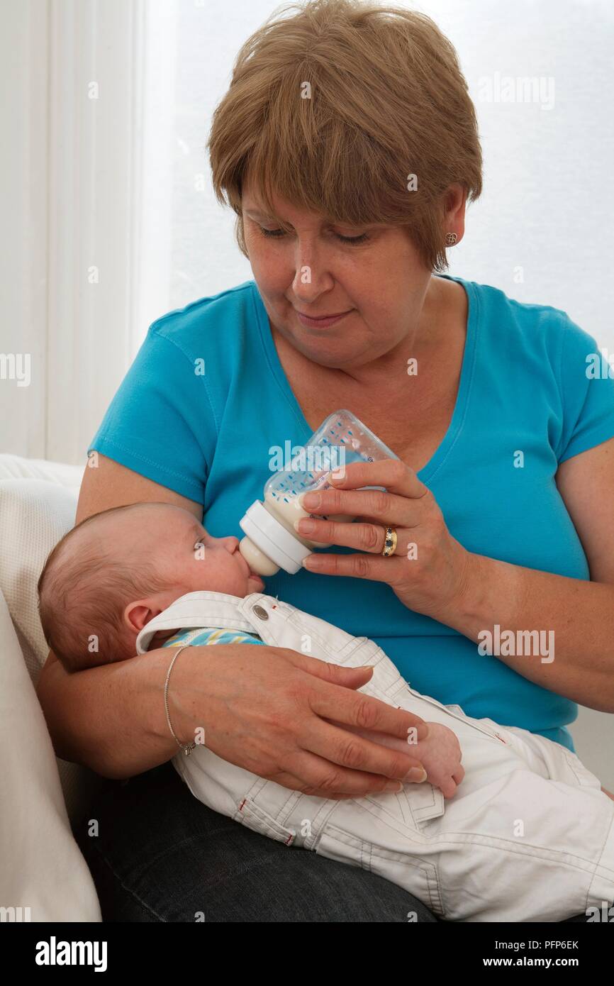 Woman feeding baby boy with bottle Stock Photo - Alamy