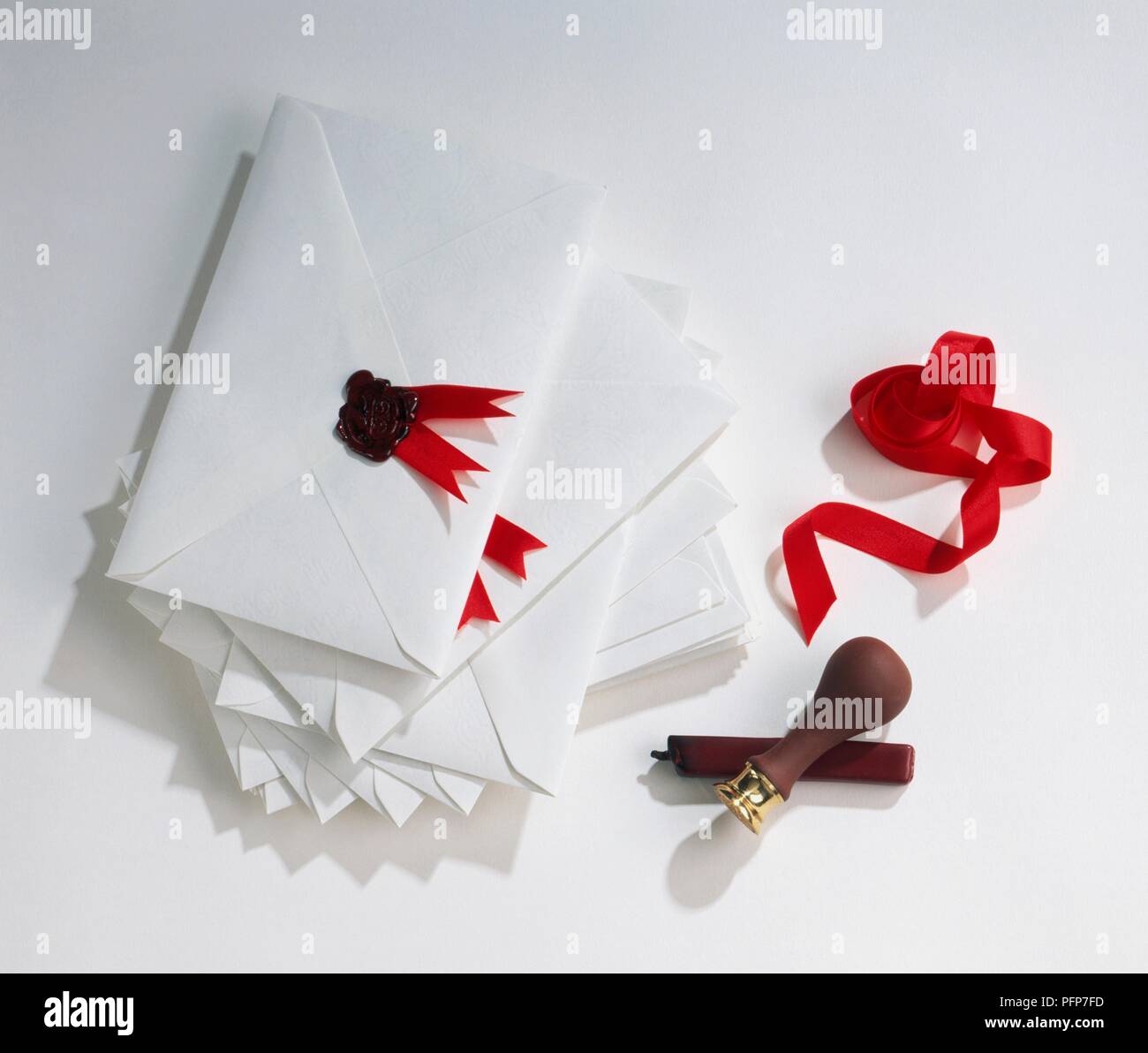 Stack of envelopes with seal, red ribbon, and wax Stock Photo - Alamy
