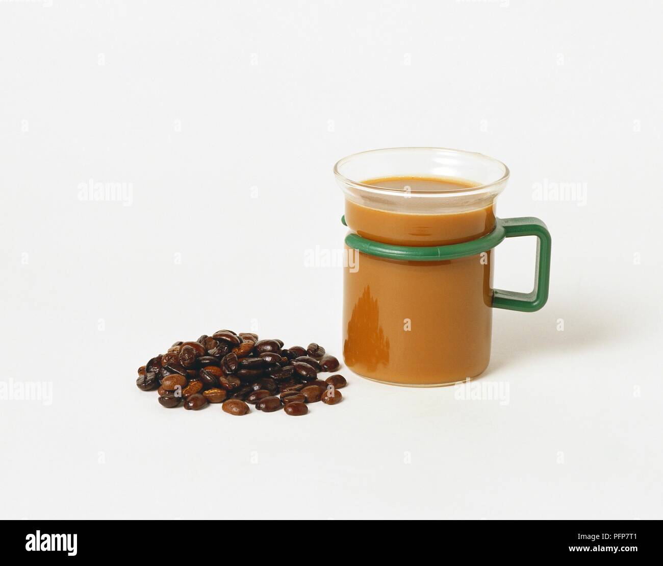 Cup of coffee on heap of coffee beans Stock Photo - Alamy
