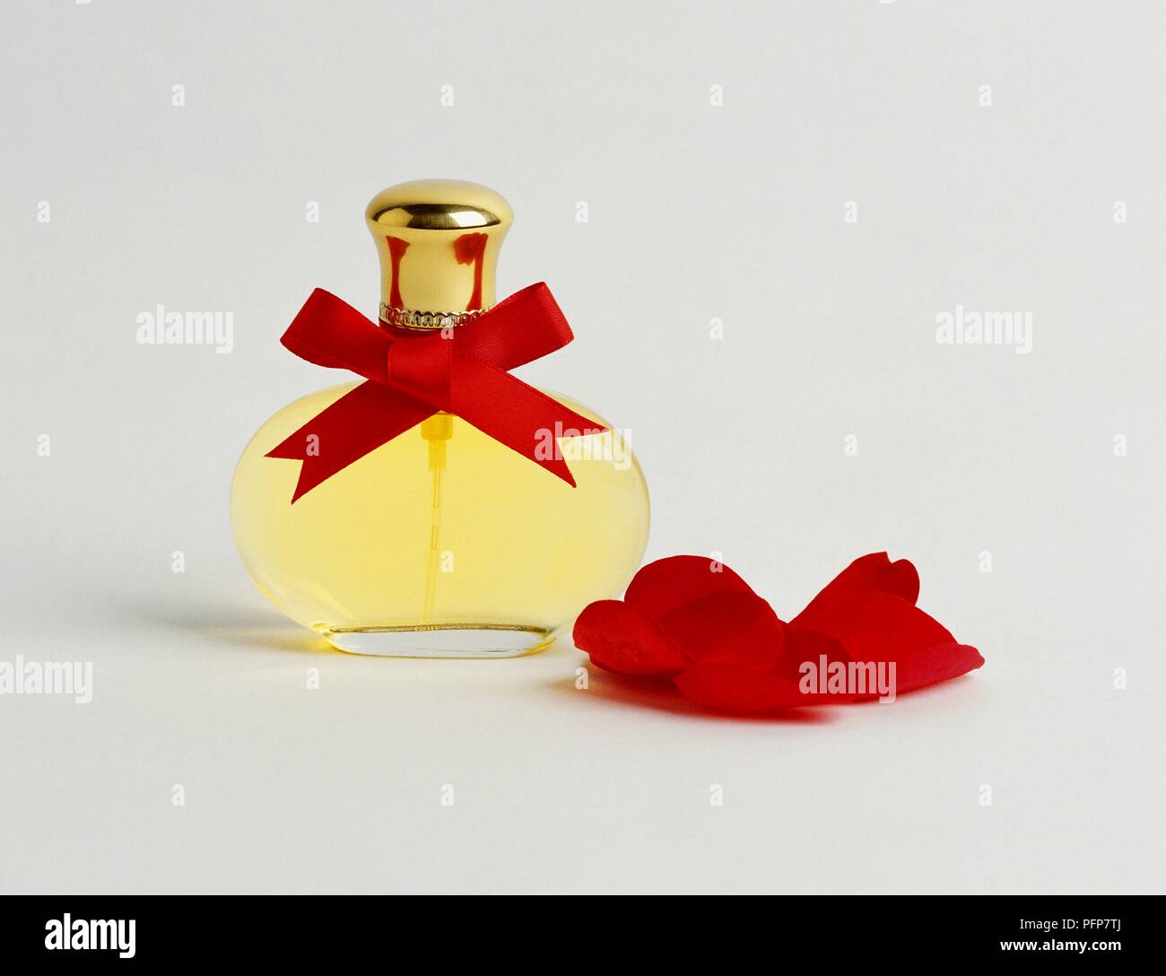 Bottle of perfume with red bow and heap of red rose petal Stock Photo ...