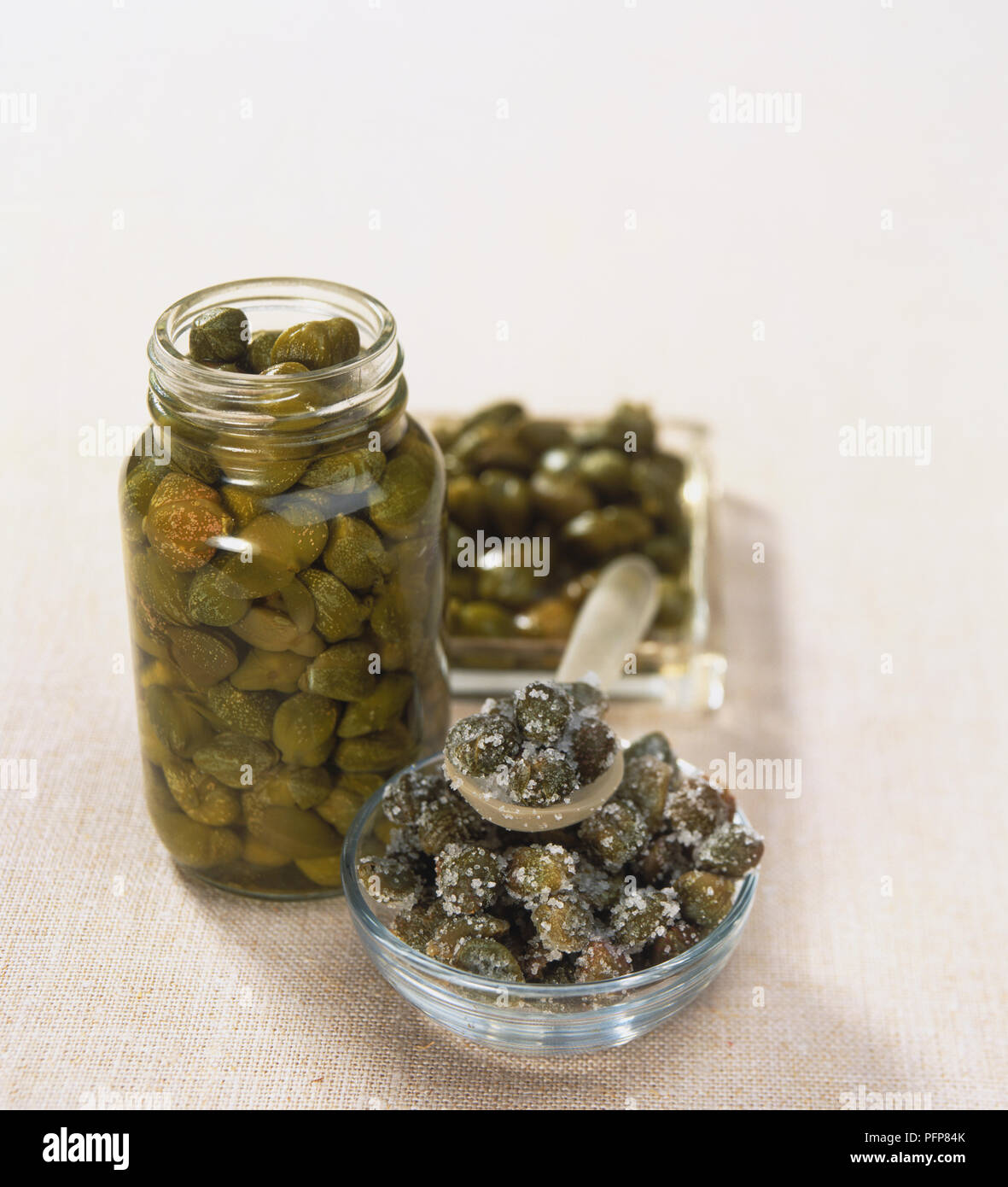 Pickled capers in glass jar, salted capers in small glass dish Stock ...