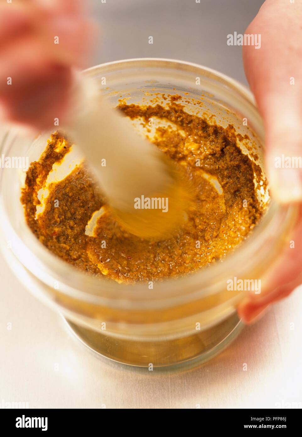 Using pestle in sieve to grind spices with ginger and water Stock Photo ...