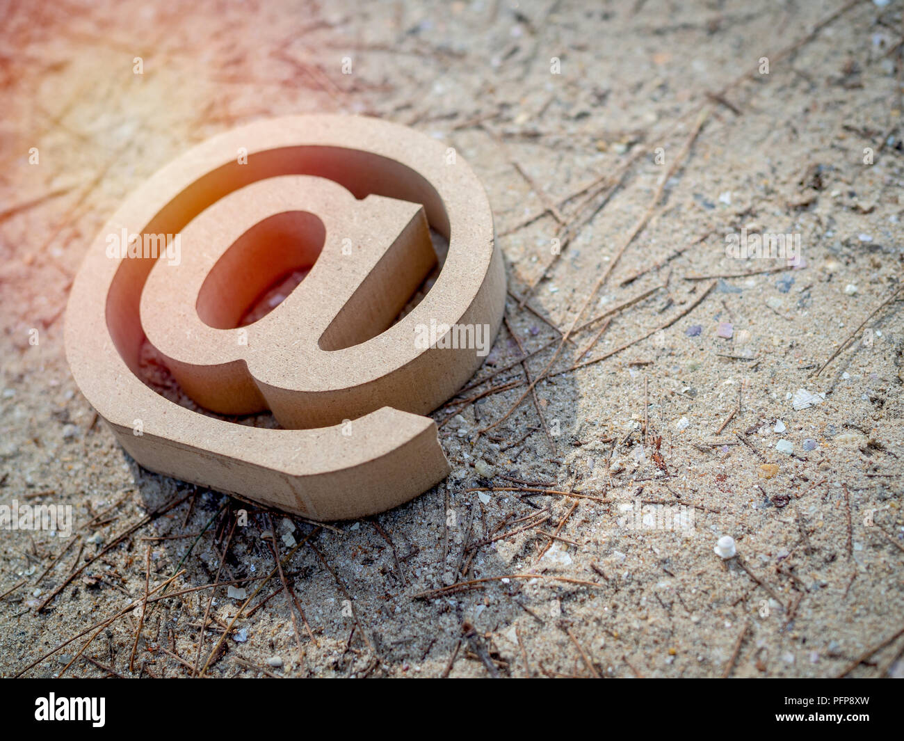 Wooden E-mail address symbol, arroba icon on sand beach texture ...