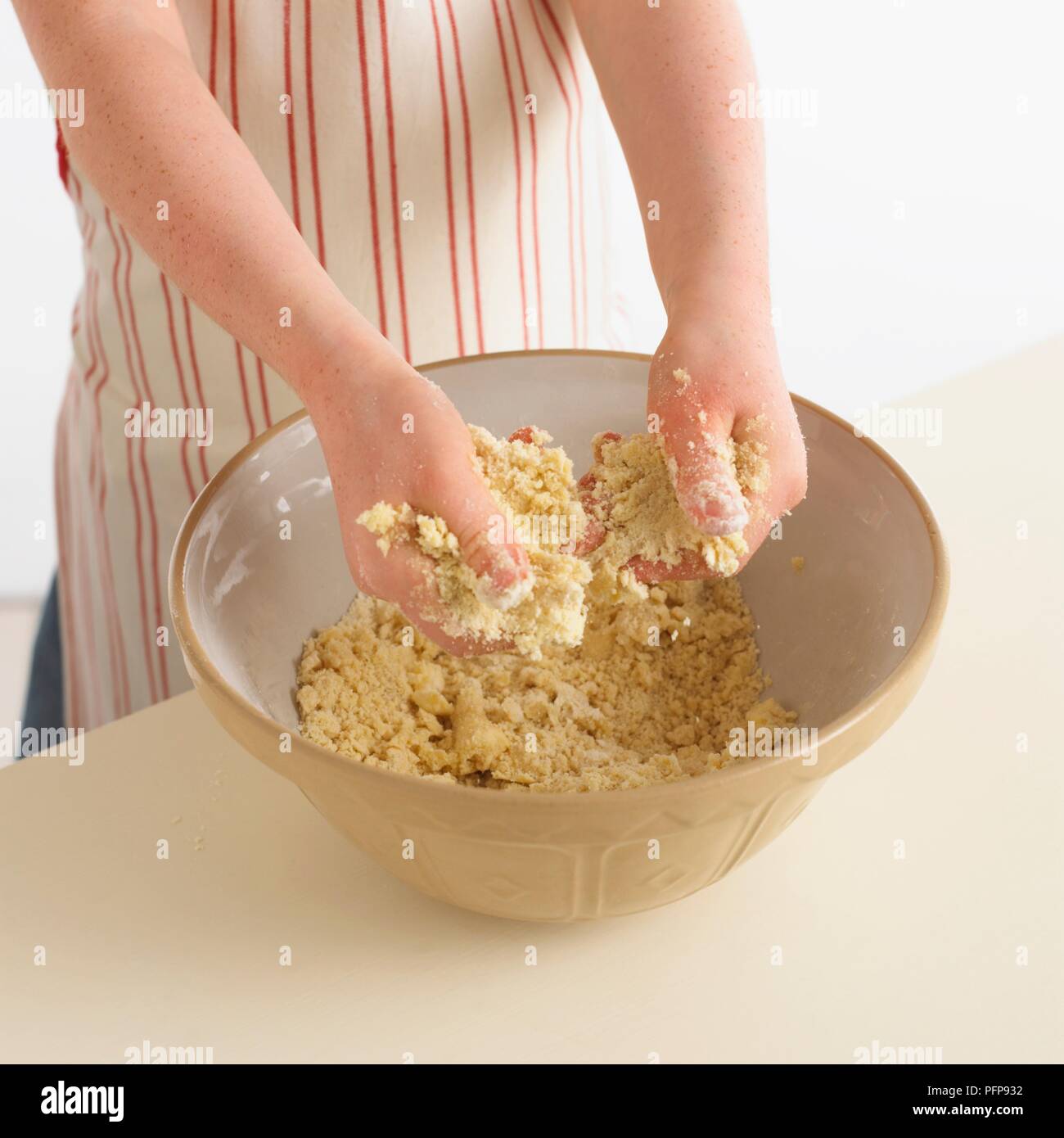 Girl using hands to mix pastry ingredient Stock Photo - Alamy