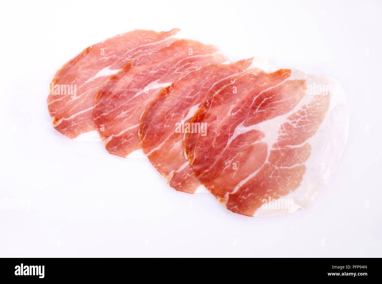 Four slices of culatello ham Stock Photo - Alamy