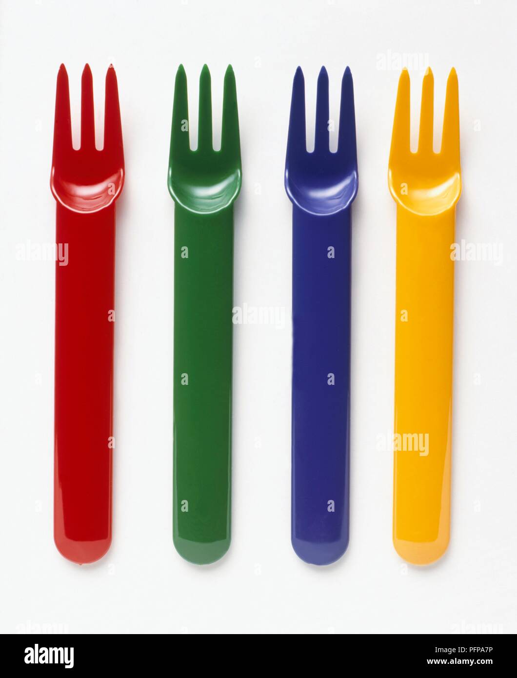 Four different coloured plastic forks in a row Stock Photo - Alamy