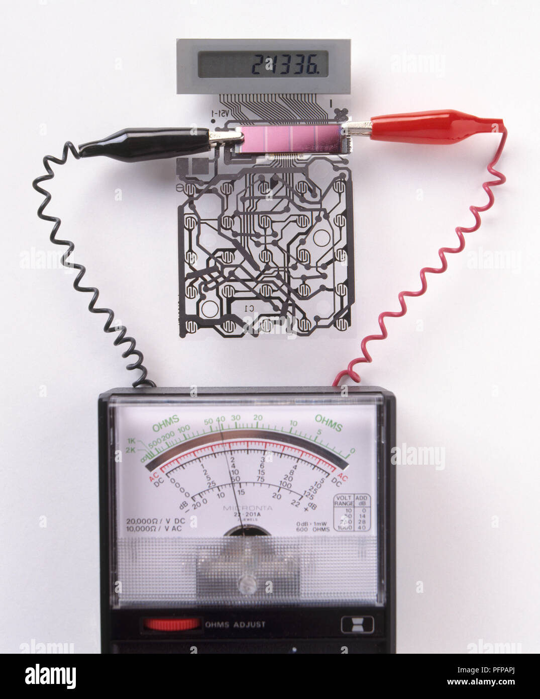A solar cell inside a calculator connected to a a multimeter, measuring ...