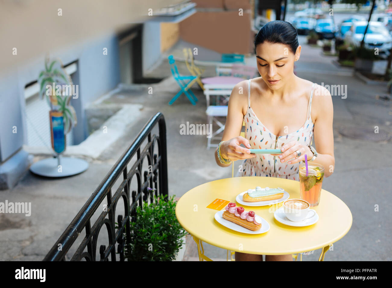 Calm woman taking photos of her dessert before eating it Stock Photo ...