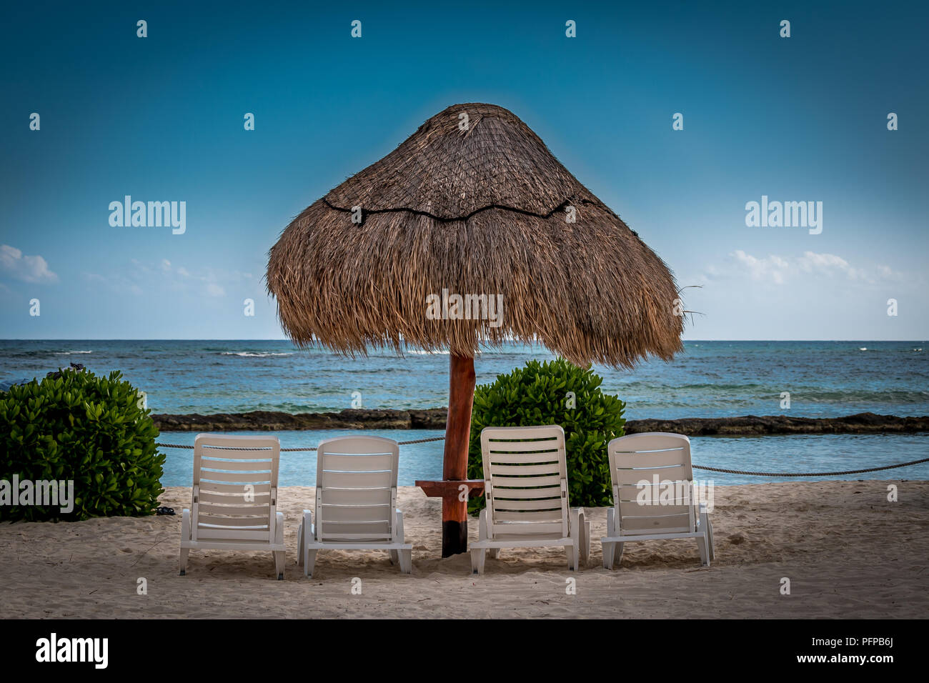 Palapa and lounge chairs on a beach in Fatima Bay, Puerto Aventuras ...