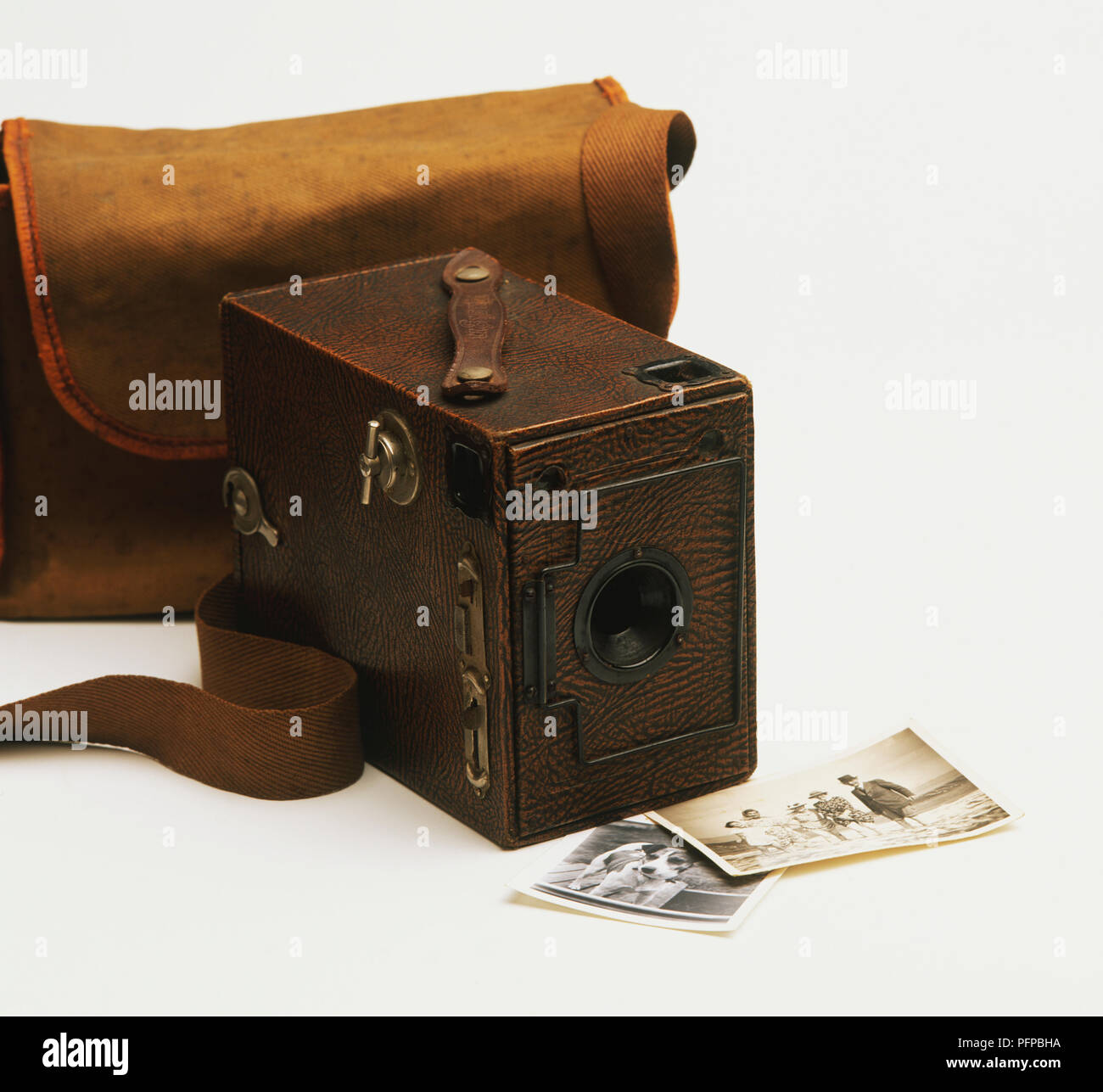 Old leather-covered box camera, brown bag, two black and white ...