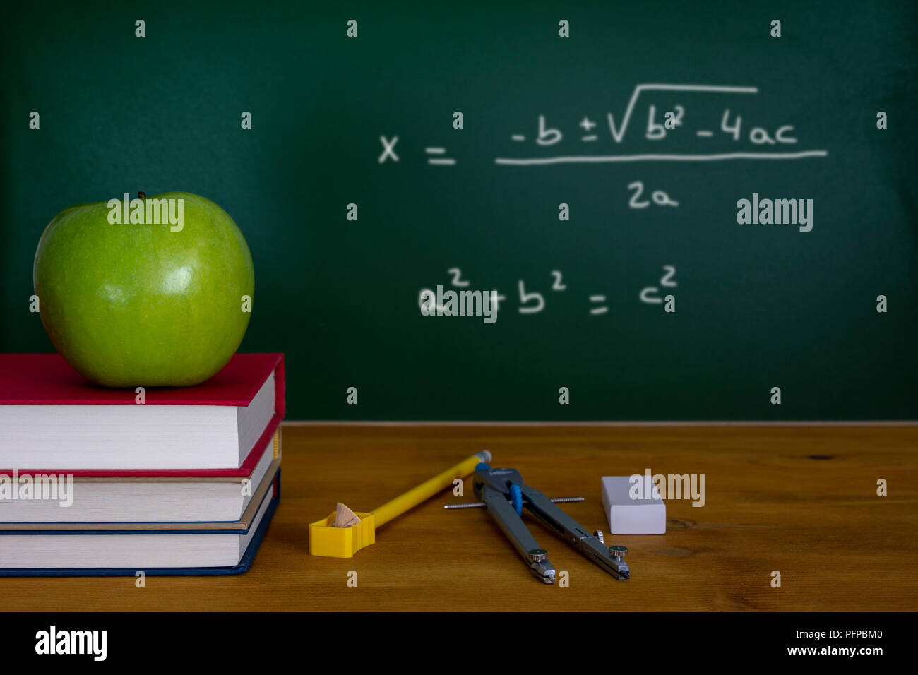 Mathematics class concept with green apple on pile of books and drawing ...