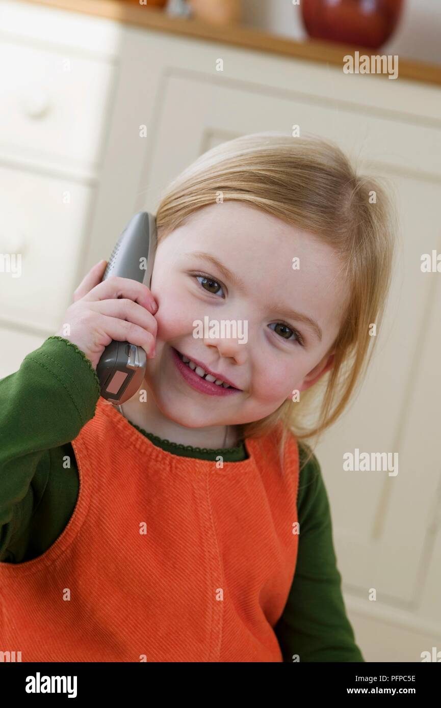 Girl holding mobile phone to ear, smiling Stock Photo - Alamy