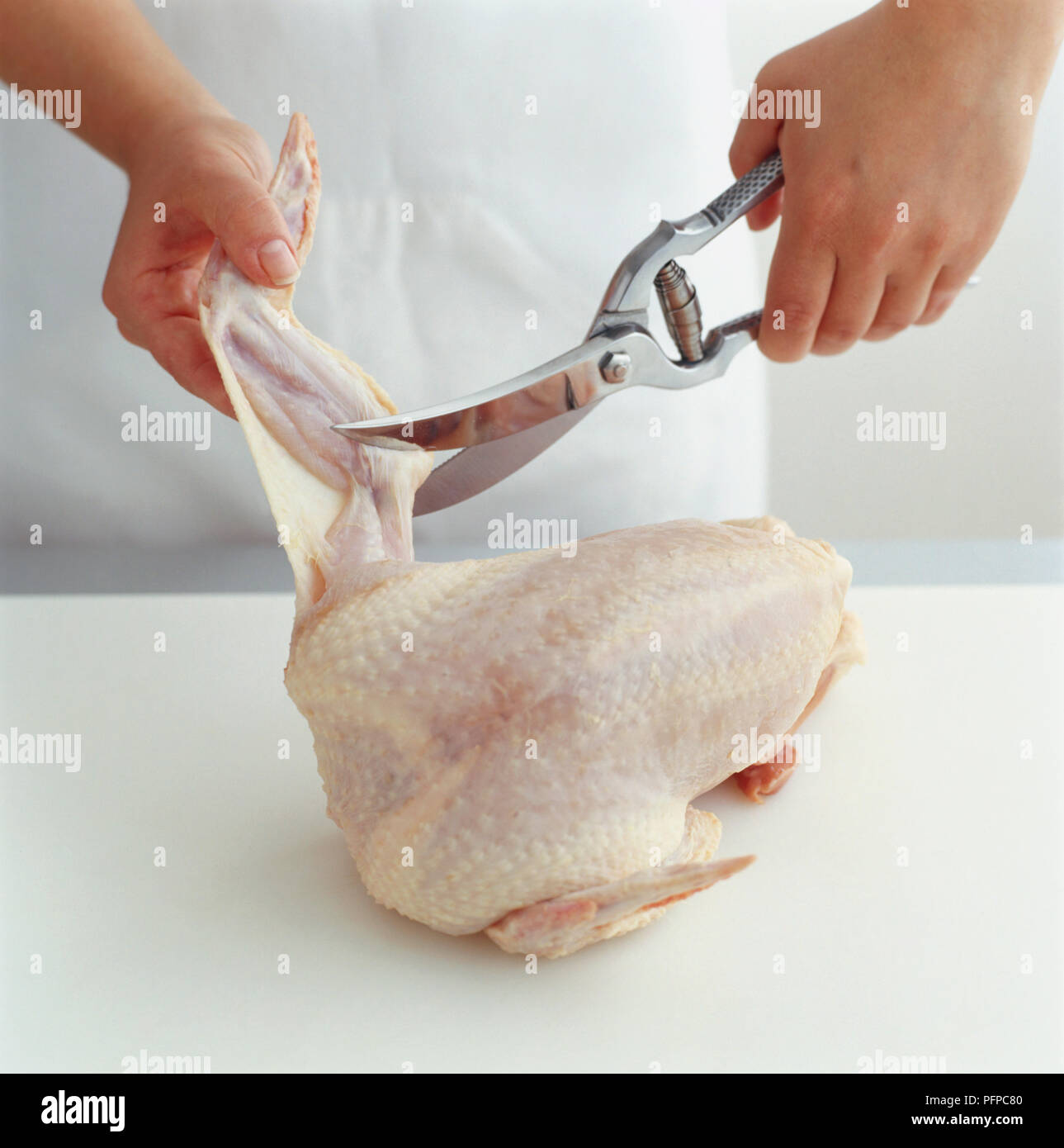 Using p0ultry shears to cut wing off raw chicken Stock Photo - Alamy