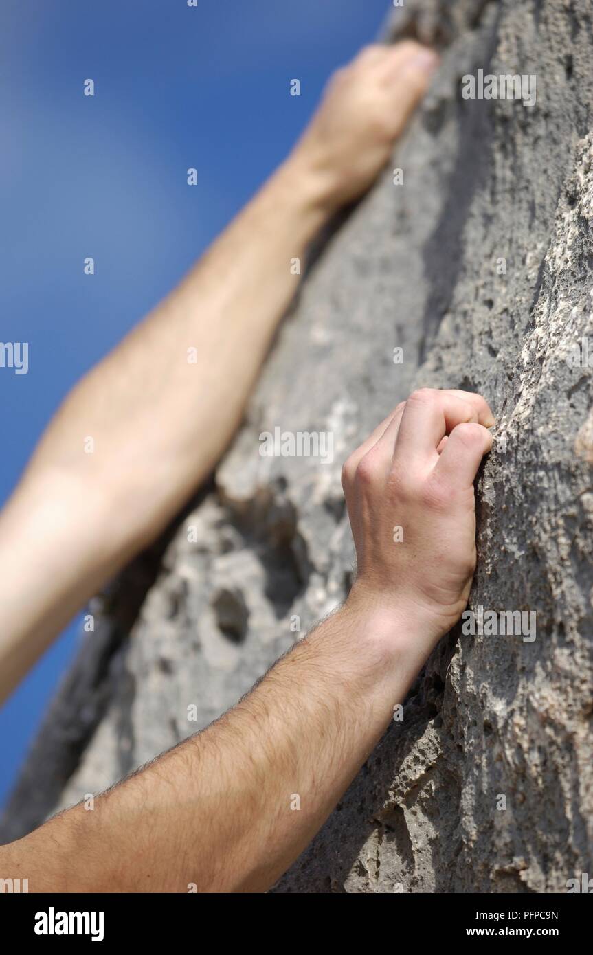 Hands gripping rock face, close-up Stock Photo - Alamy