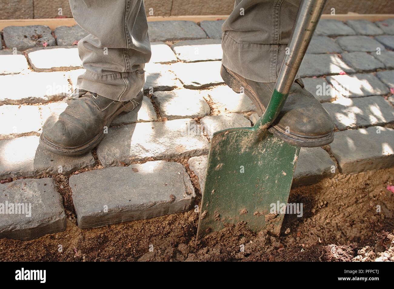 Man standing on laid brick path with spade in soil, close-up Stock ...