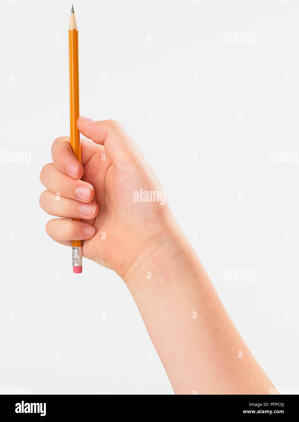 Child's hand holding pencil vertically, thumb marking middle of pencil ...