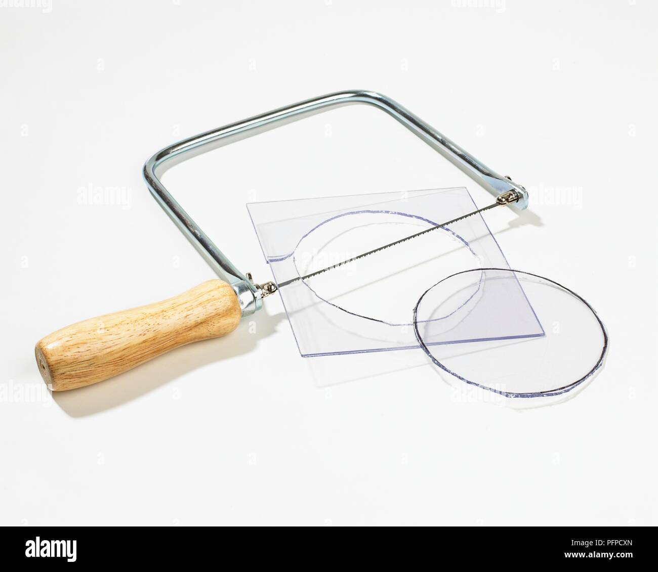 Small hacksaw with plastic circle cut from sheet Stock Photo - Alamy