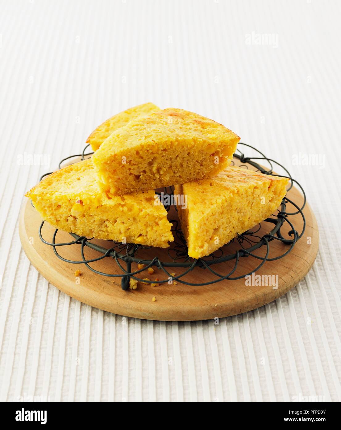 Corn bread slices on rack on wooden chopping board Stock Photo - Alamy