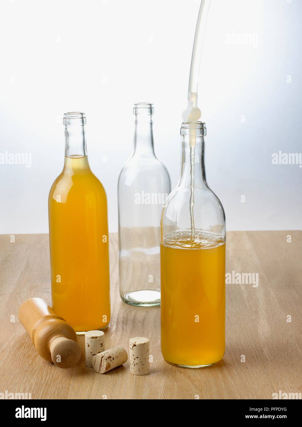 Siphoning home-made cider into glass bottles Stock Photo - Alamy