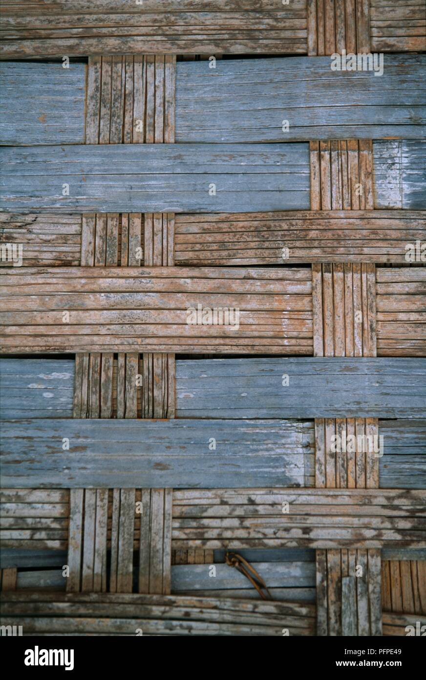 Close-up view of woven panels of rattan lashed together to form houses ...