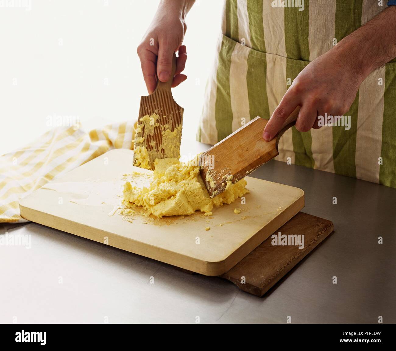 Using pair of wooden paddles to shape butter on chopping boards Stock ...