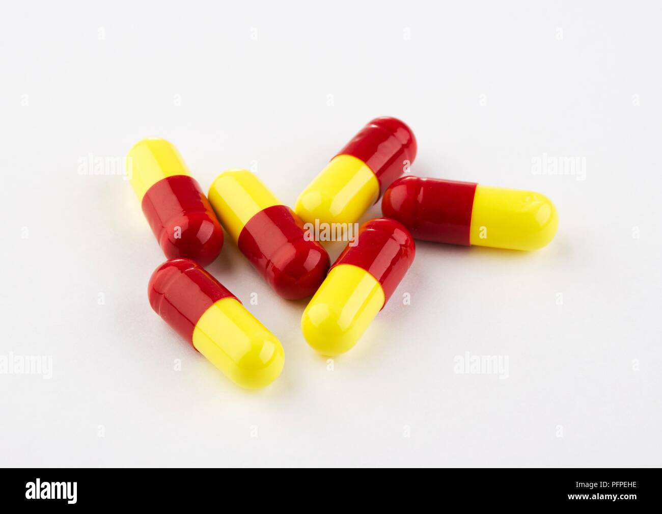 Yellow and red cold and flu capsules Stock Photo - Alamy