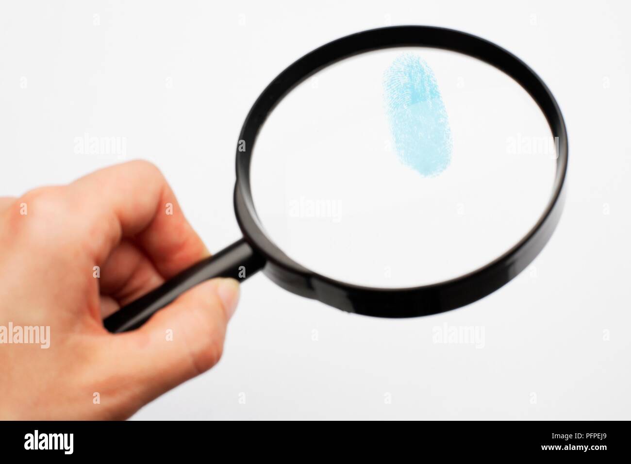 Hand holding magnifying glass over fingerprint Stock Photo - Alamy