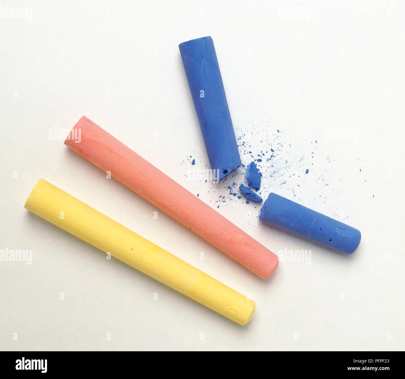 Three pieces of yellow, red and blue chalk Stock Photo - Alamy