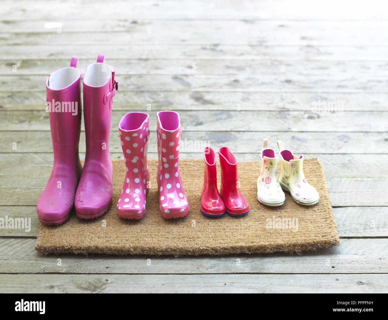 Selection of pink and white Wellington boots on a door mat Stock Photo ...