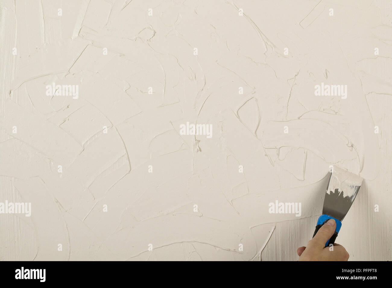Using a scraper to create a textured plaster surface Stock Photo - Alamy