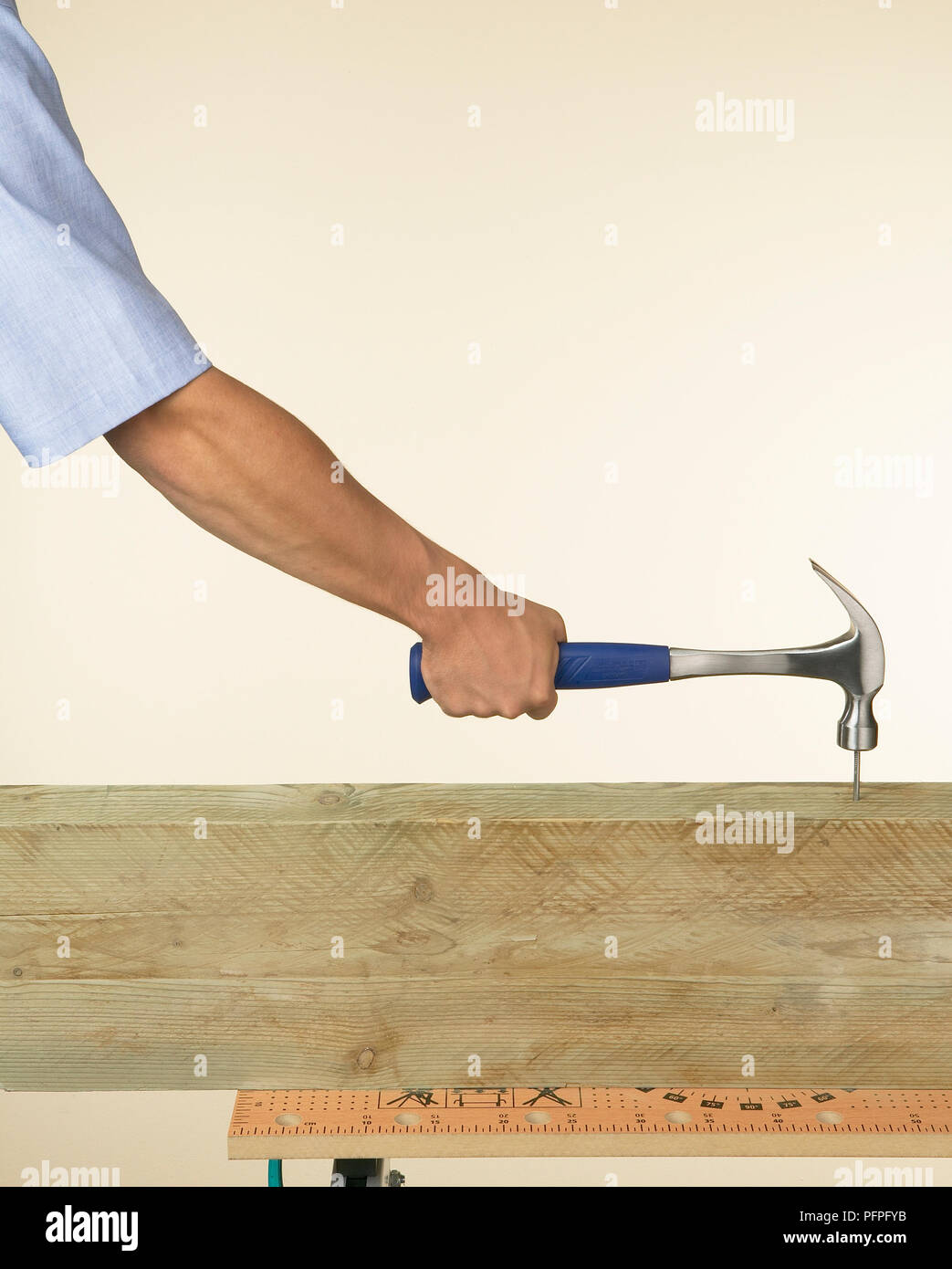Person hitting nail into wood with hammer Stock Photo - Alamy