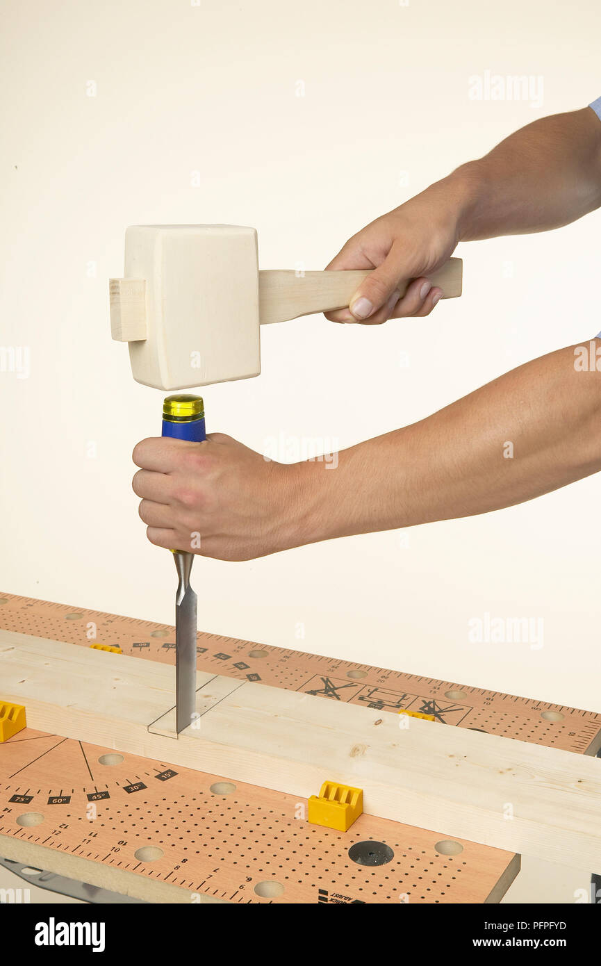 Person cutting section from wood using wooden mallet and chisel Stock ...